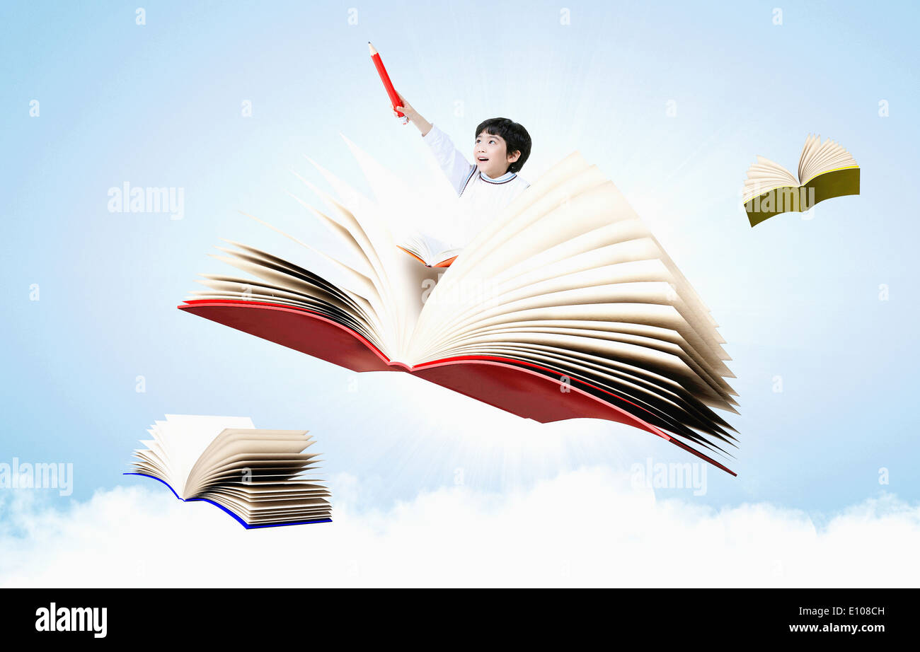 a boy flying with a book Stock Photo - Alamy