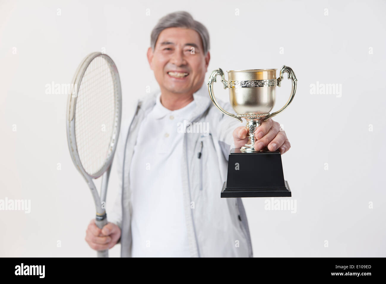 an old man with a tennis racket and a trophy Stock Photo - Alamy