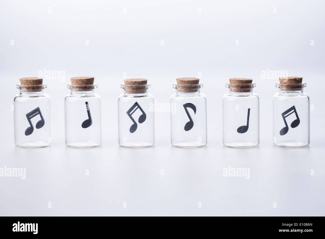 several glass jars in a line with musical notes inside of them Stock ...