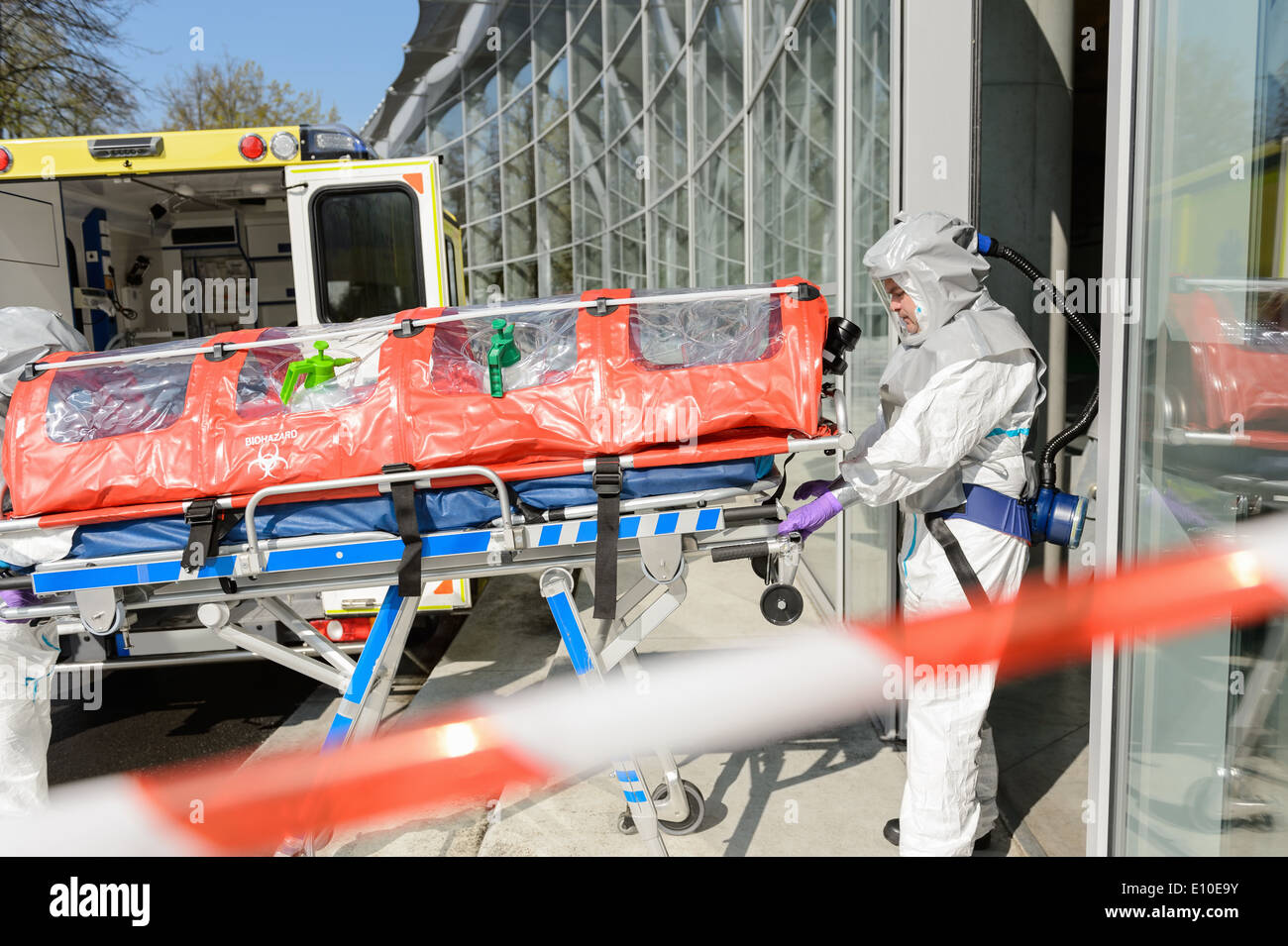 Biohazard medical team member with stretcher entering contaminated ...