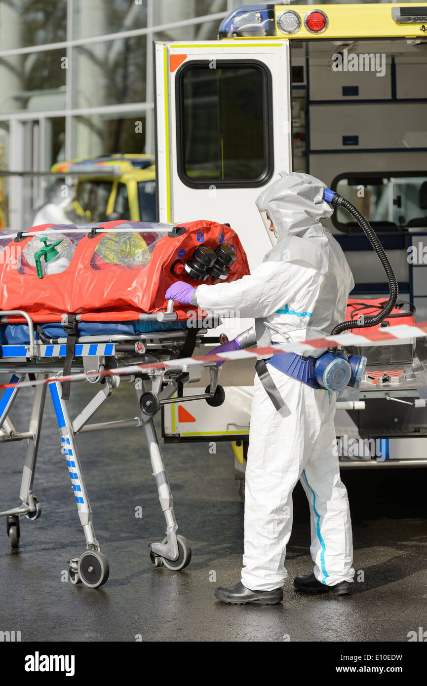HAZMAT medical team member with stretcher by ambulance on street Stock ...
