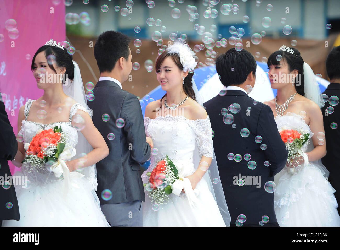 Chongqing, China. 21st May 2014. Brides and grooms attend a group ...