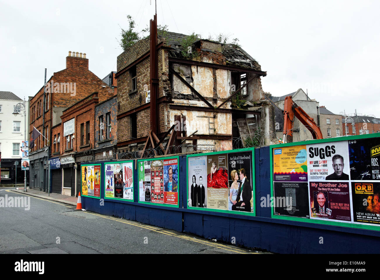 Old building being demolished, with advertisement street posters on ...