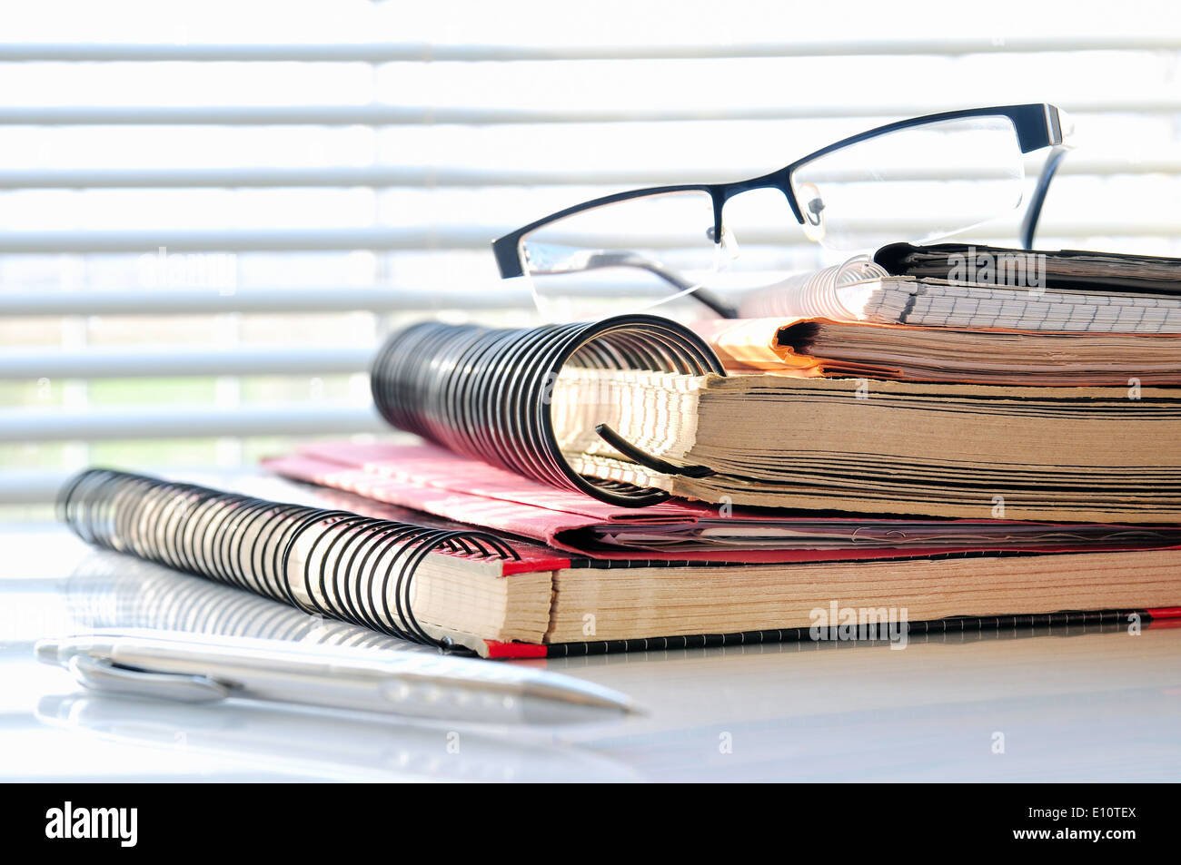 Stack of office folders with glasses and ballpoint in front of a window ...