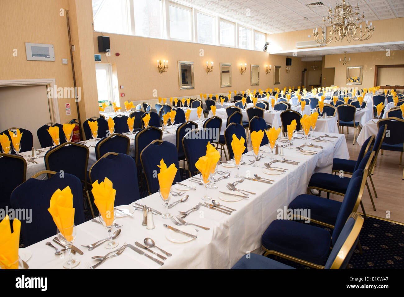An empty dining room at at a UK hotel laid out for dinner lunch meal ...