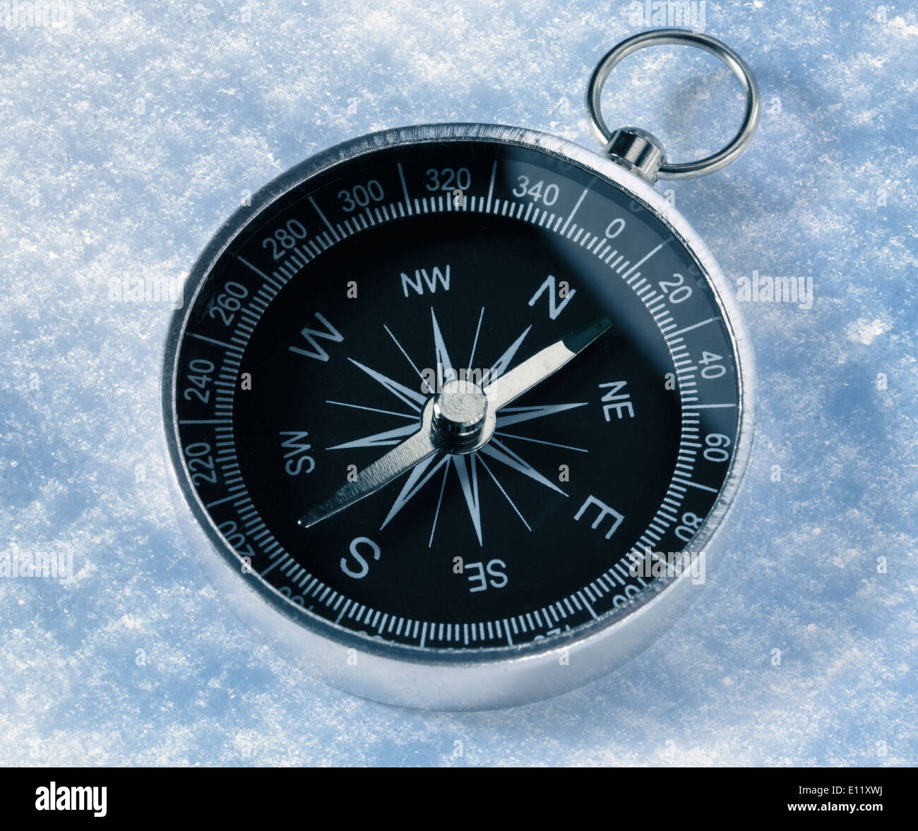Black compass on snow background Stock Photo - Alamy