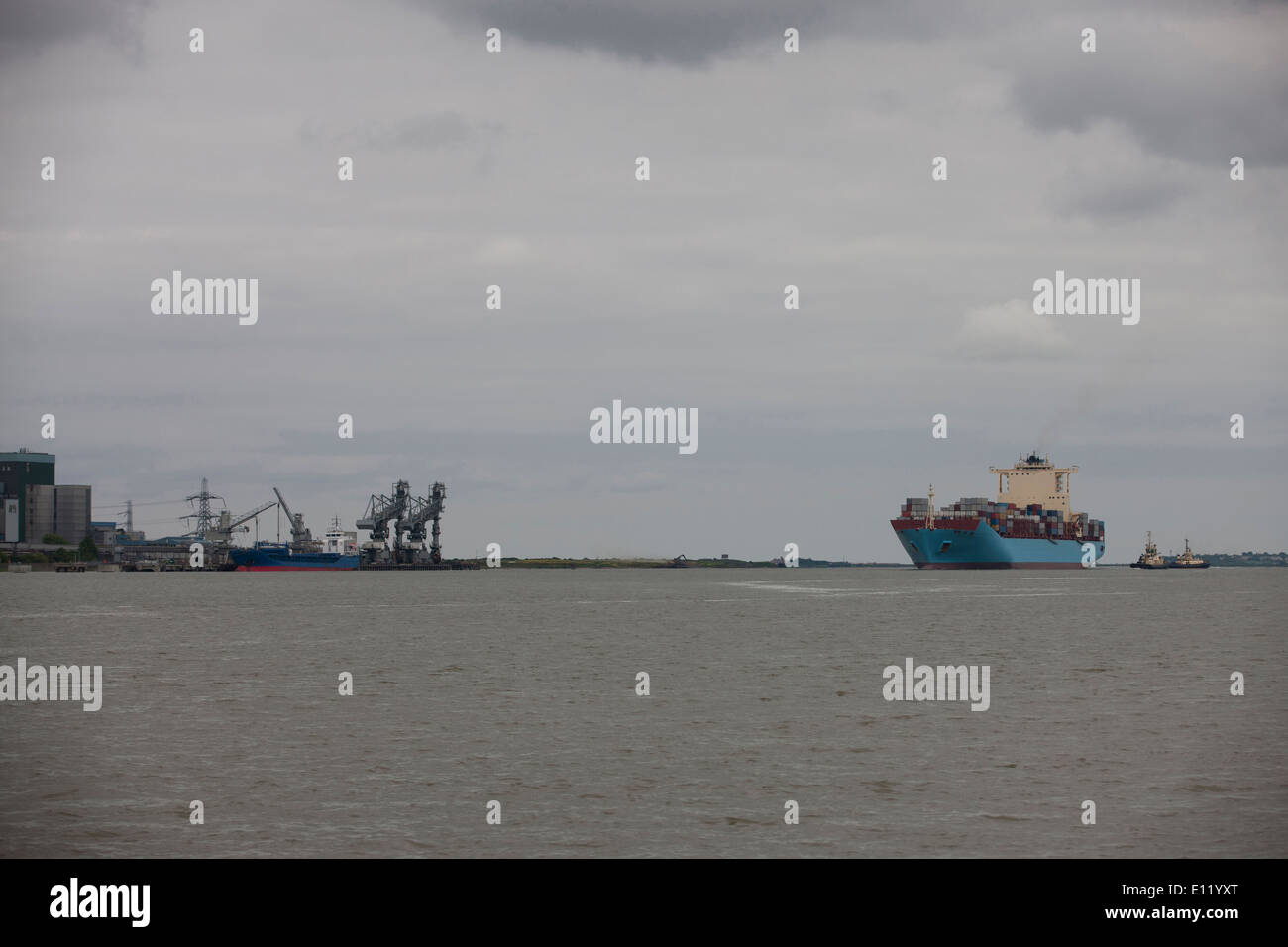 A container ship being met by two tug boats Stock Photo - Alamy