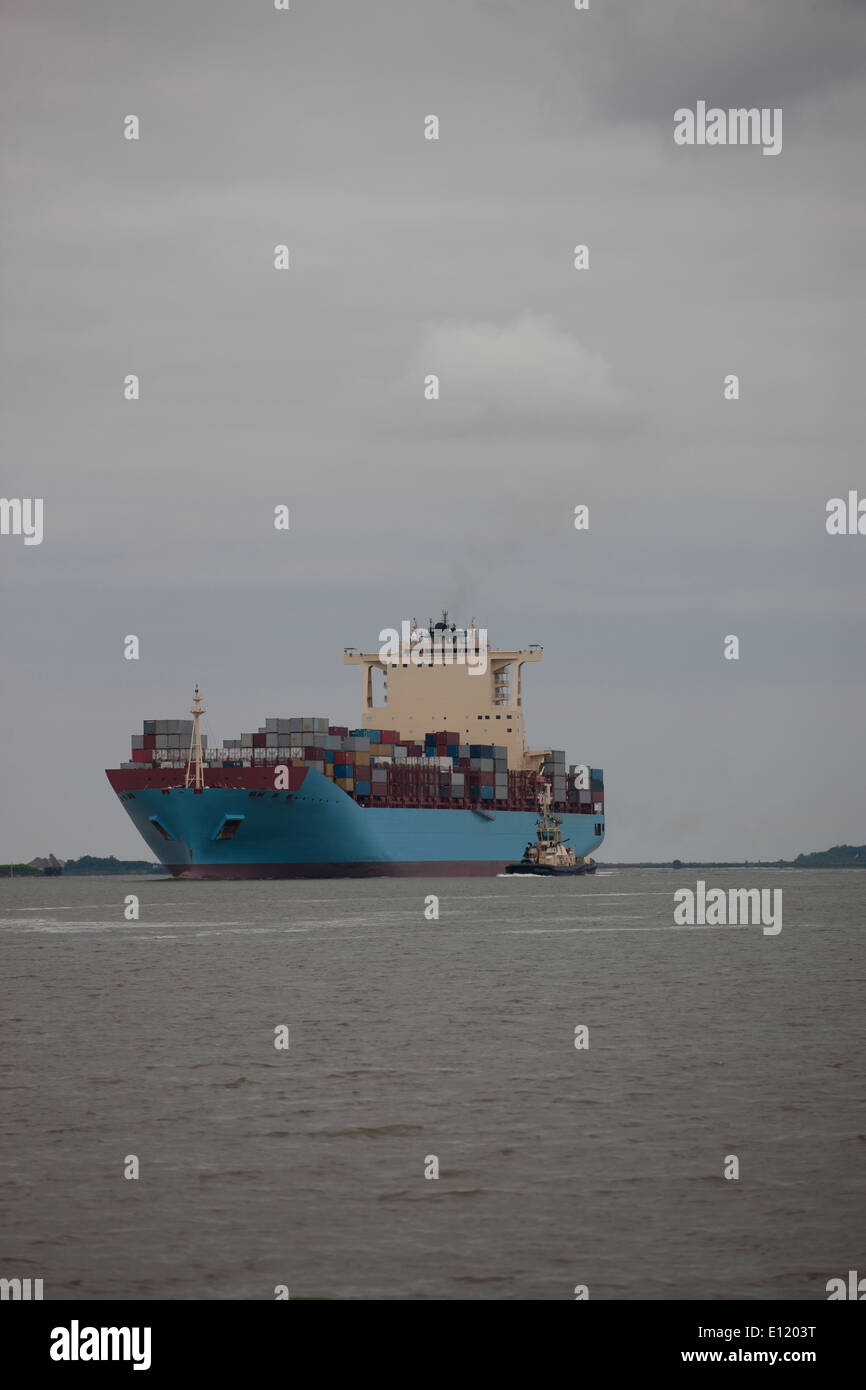 A container ship being escorted to port by a tug boat Stock Photo - Alamy