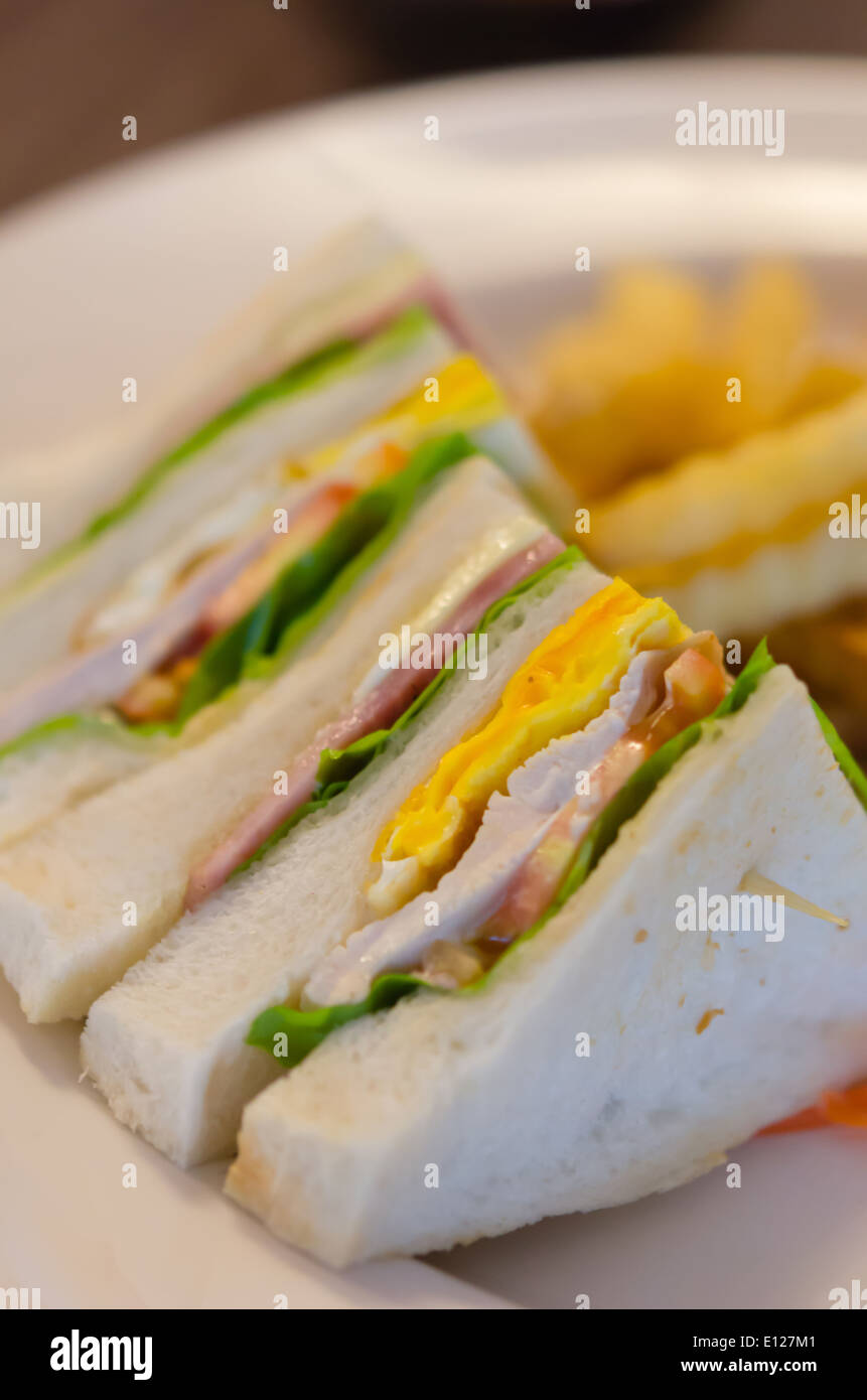 Delicious club sandwich with french fries at a dinner Stock Photo - Alamy