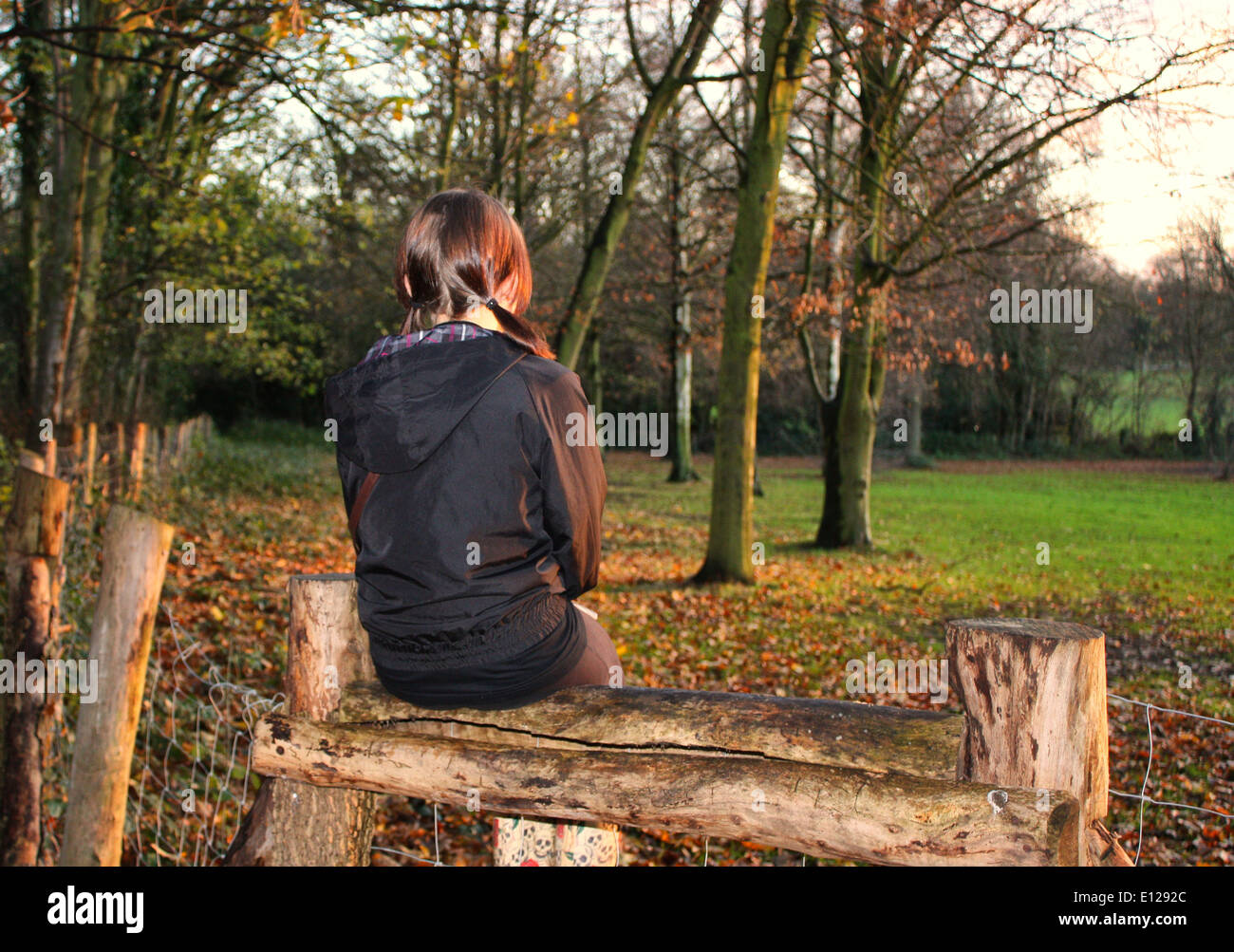 lonely girl on stye in autumn park scene Stock Photo - Alamy