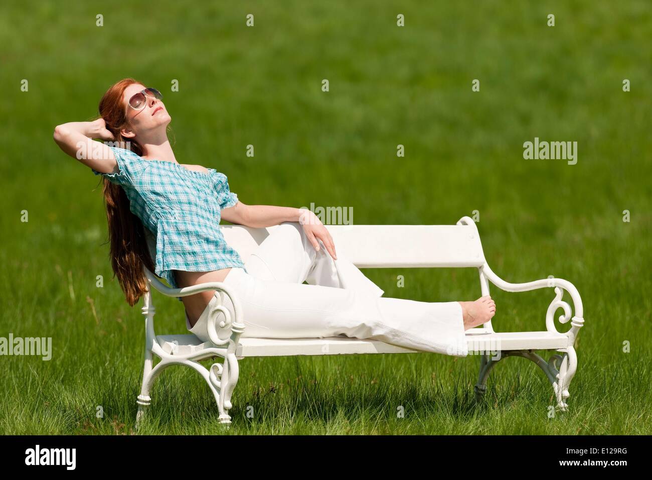 Woman sitting barefoot on a bench in the park hi-res stock photography ...