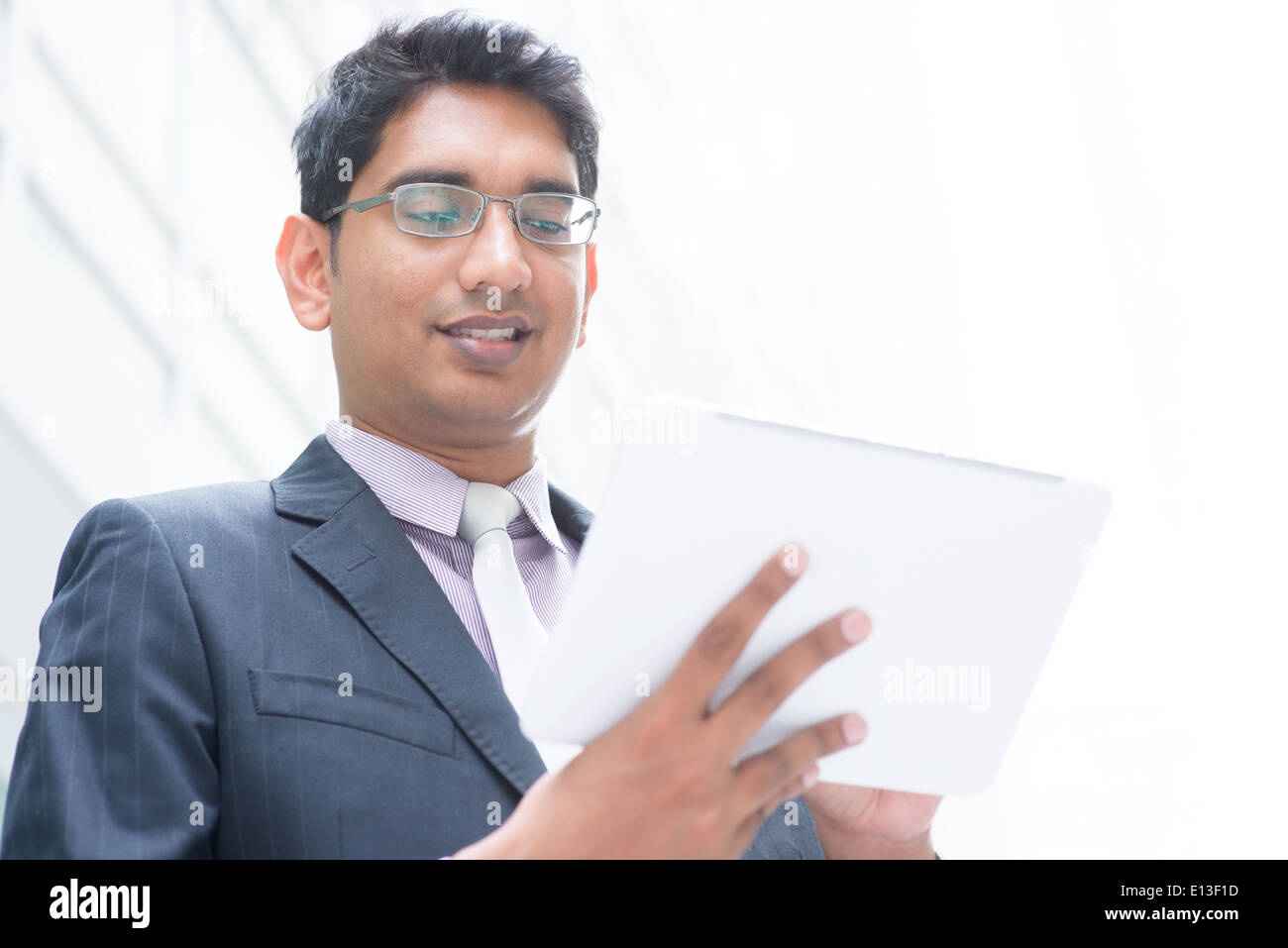 Indian businessman using digital computer tablet, modern office ...