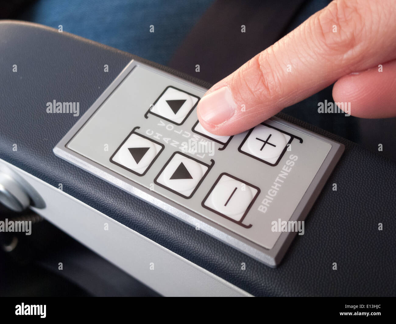 Human finger pressing push buttons on the armrest of airplane se Stock ...