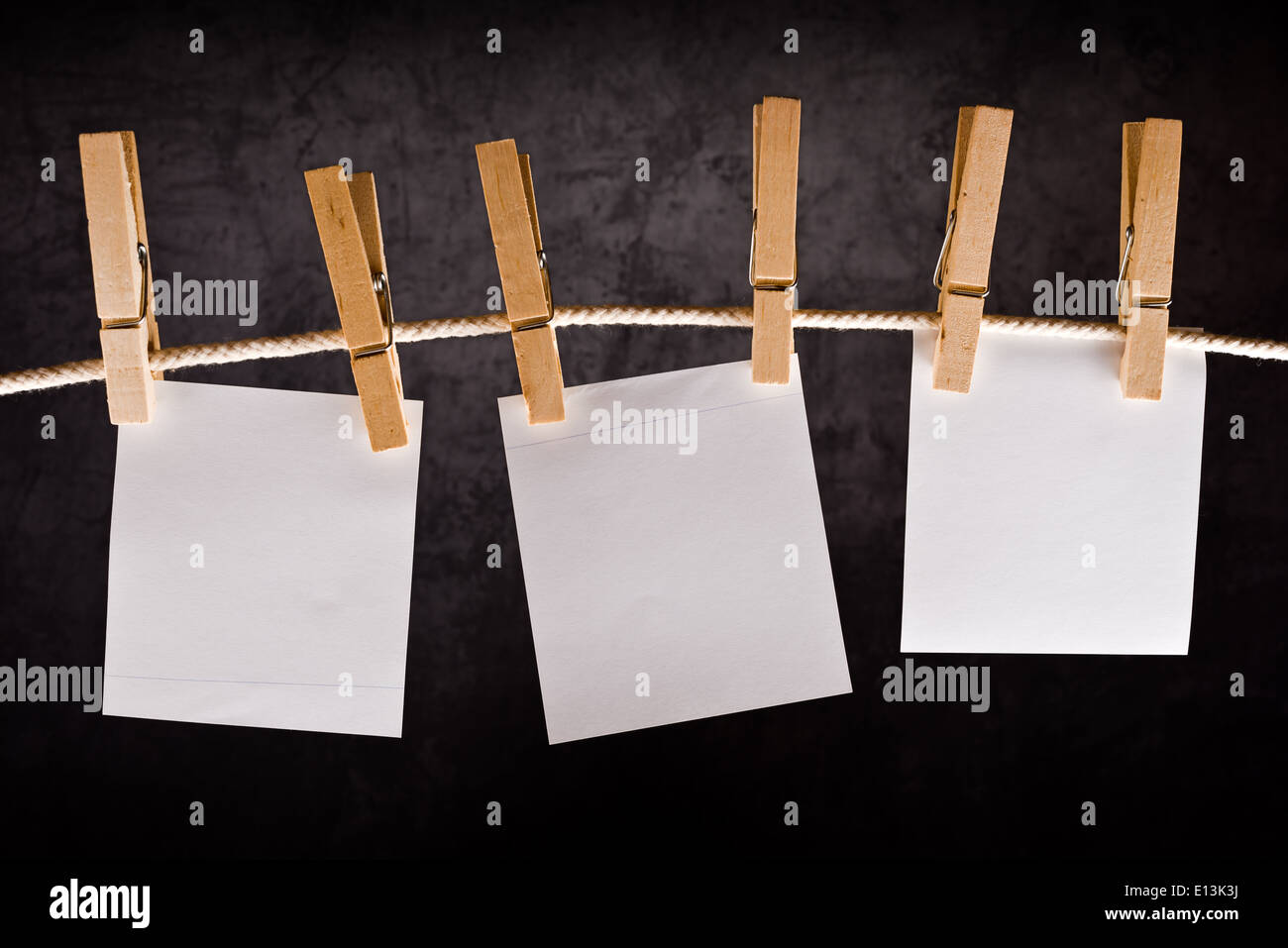 Three Blank paper notes hanging on rope with clothes pins, copy space ...