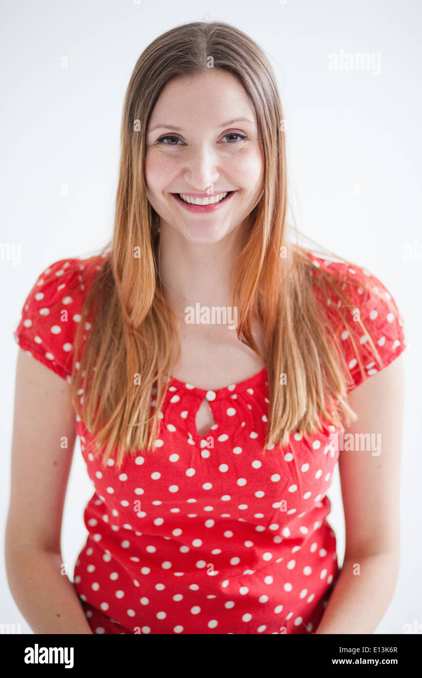 Studio portrait of happy smiling attractive woman wearing red blouse ...