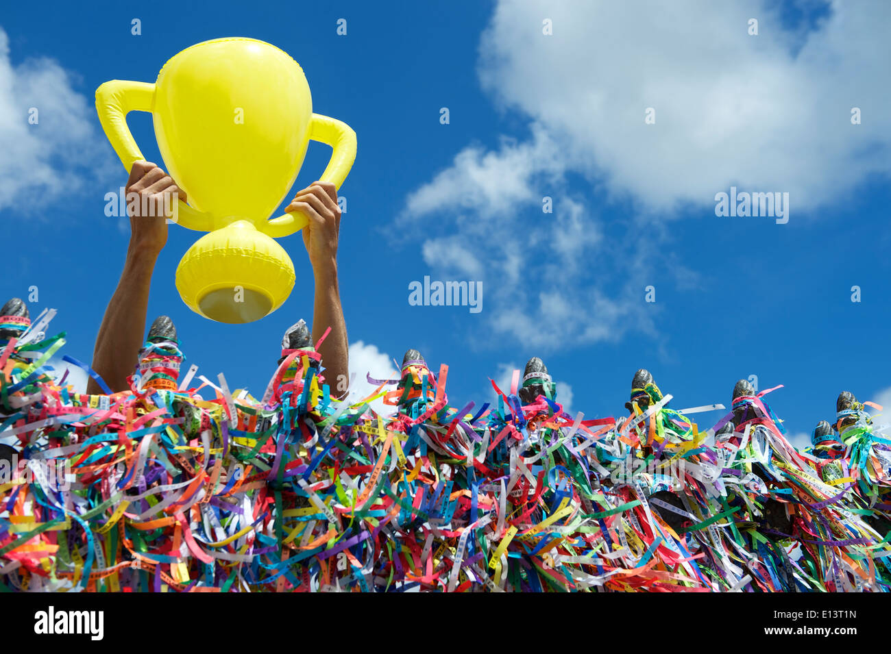 Hands holding good luck championship trophy at wall of Brazilian wish ...