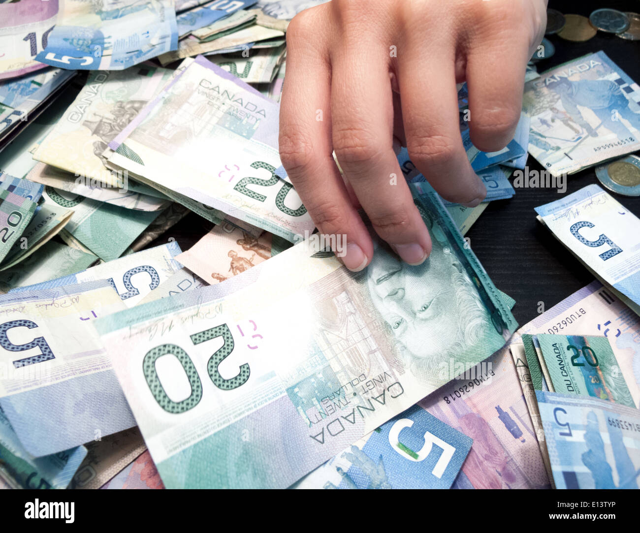 Person's hands picking Twenty Canadian Dollar Bill from heap of Stock ...