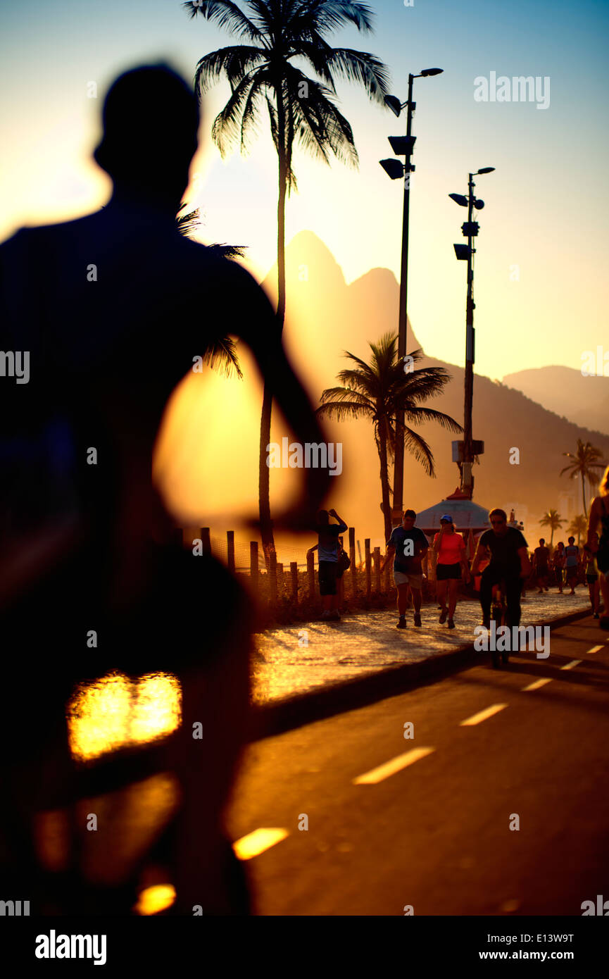 Active silhouettes of people biking and walking on sunset bike path in ...