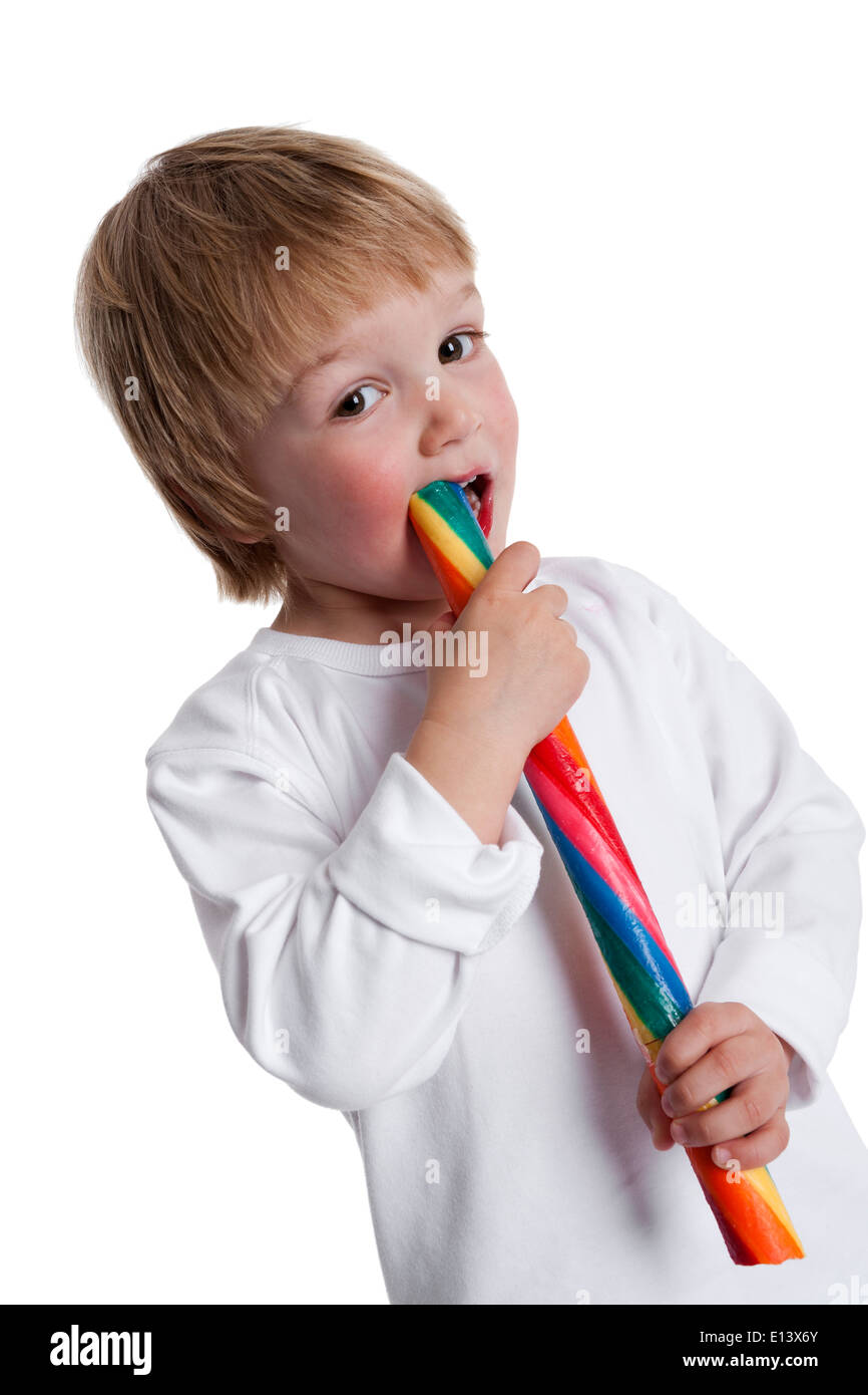 Little boy eating a candy cane on white background Stock Photo - Alamy