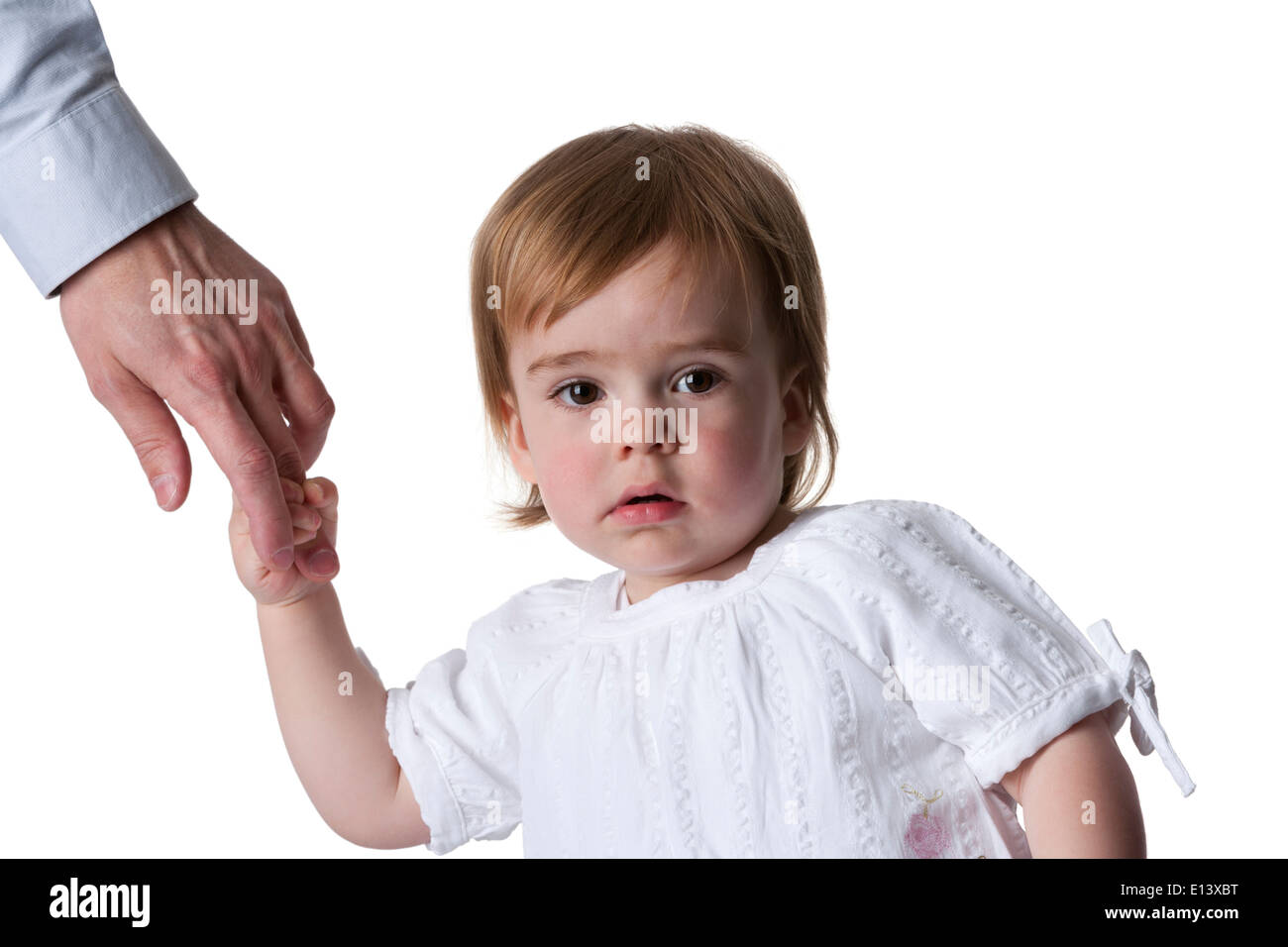 Portrait of a doubting little girl holding on fathers hand on white ...