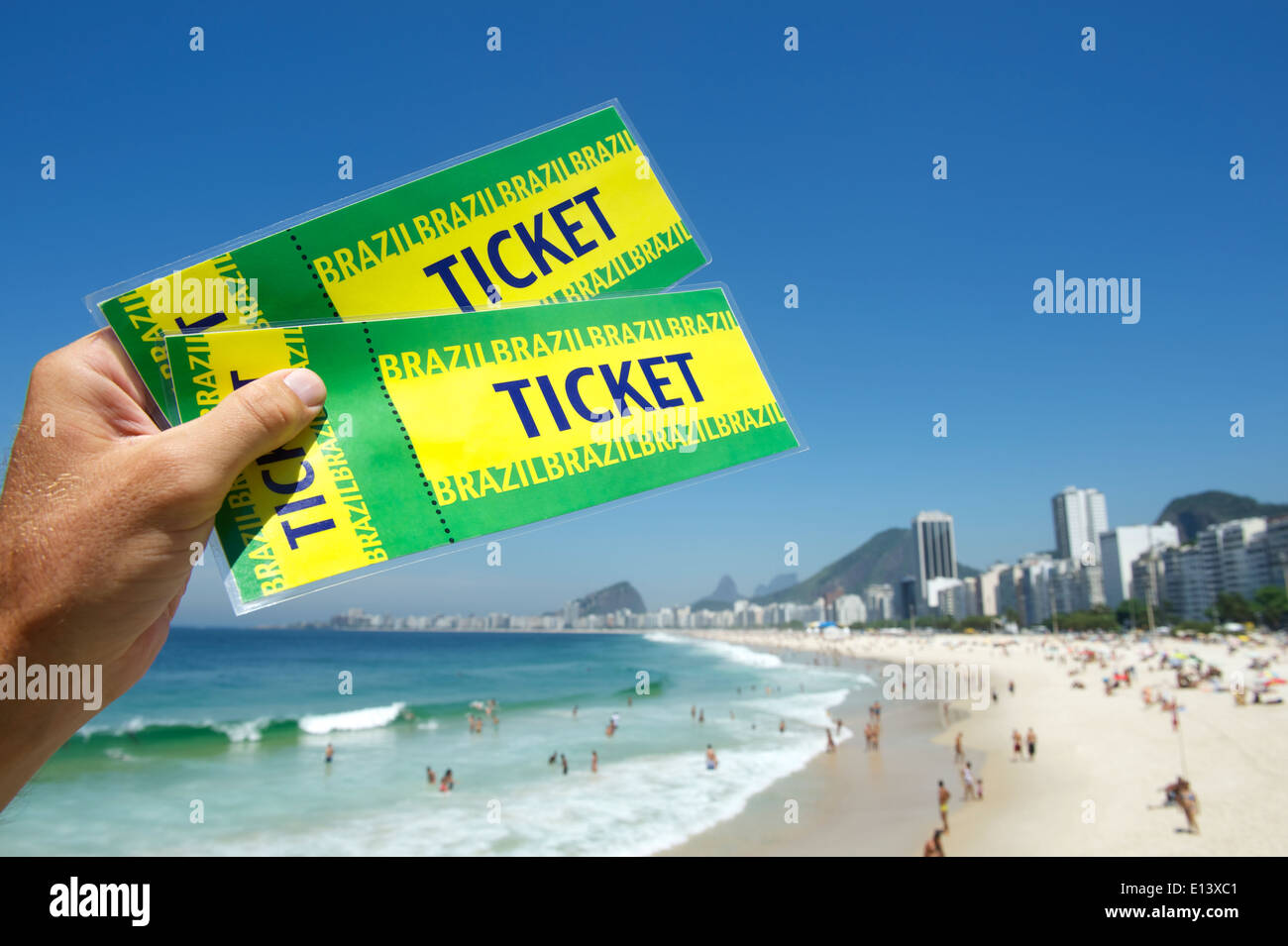 Hand holding pair of Brazil tickets at Copacabana Beach Rio de Janeiro ...