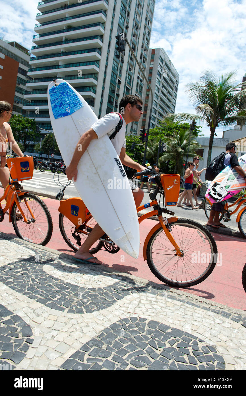 RIO DE JANEIRO, BRAZIL - OCTOBER 27, 2013: Man rides a bicycle carrying ...