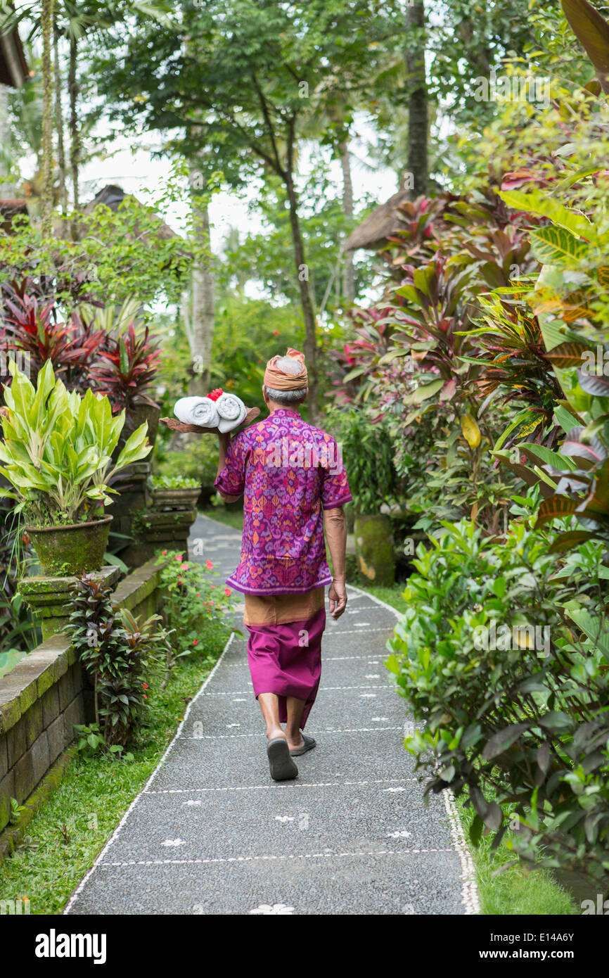 Balinese worker walking along path Stock Photo - Alamy