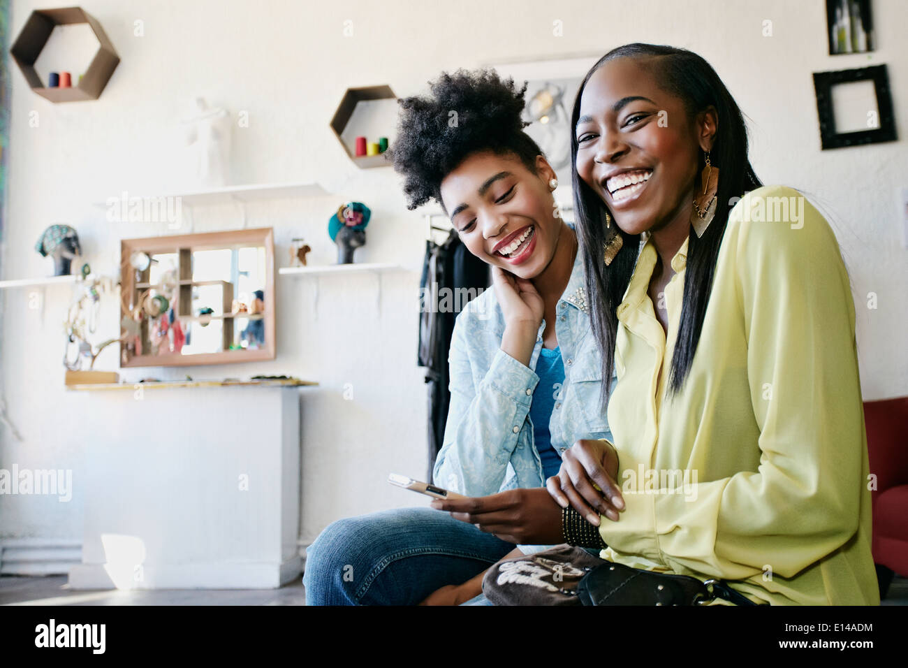 Women using cell phone in store Stock Photo - Alamy
