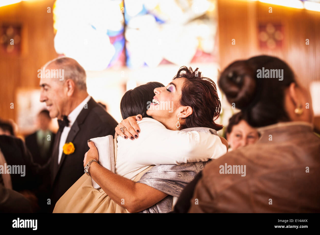 Hispanic family hugging at wedding reception Stock Photo - Alamy