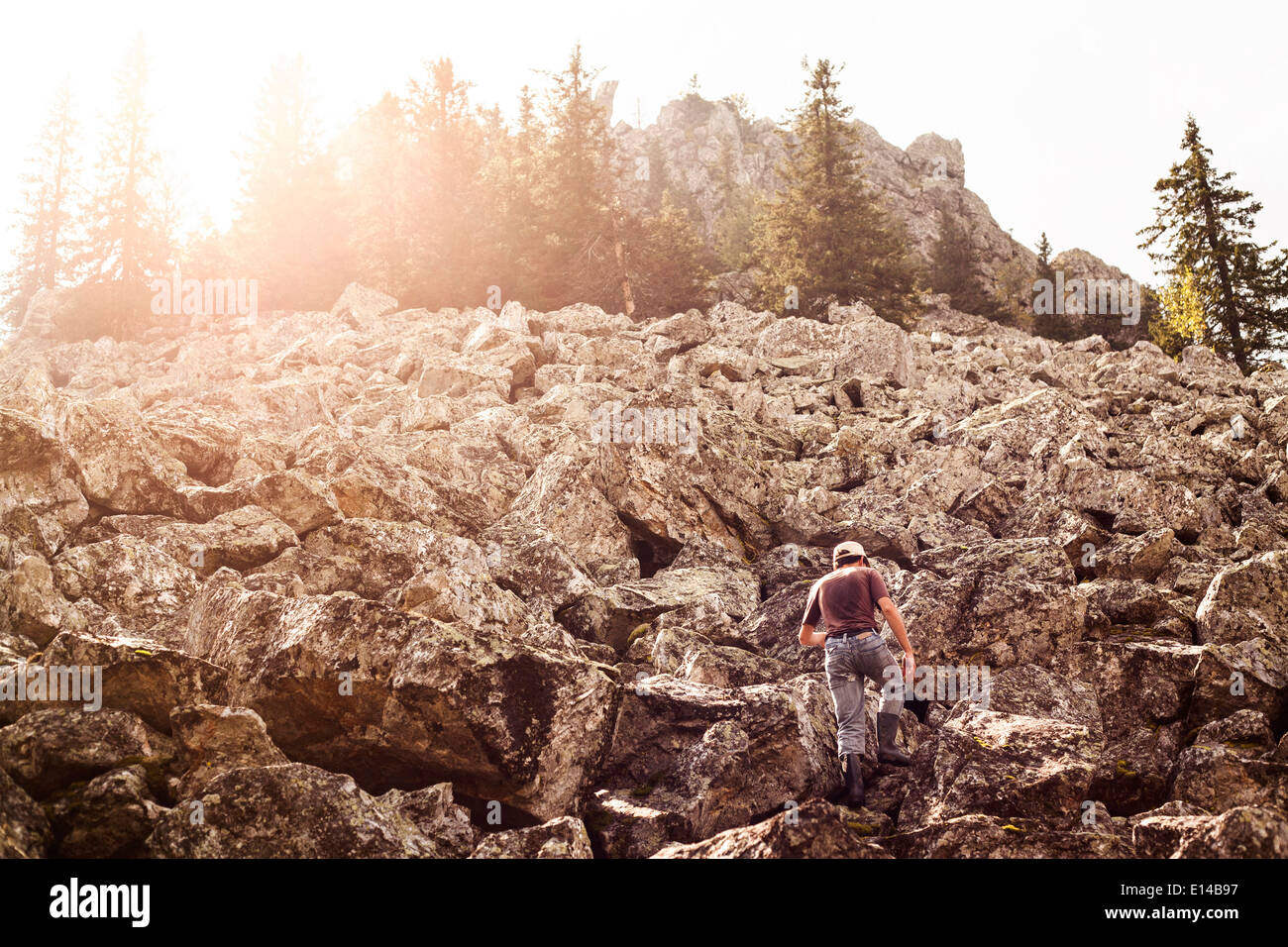 Man climbing rocky hillside Stock Photo - Alamy