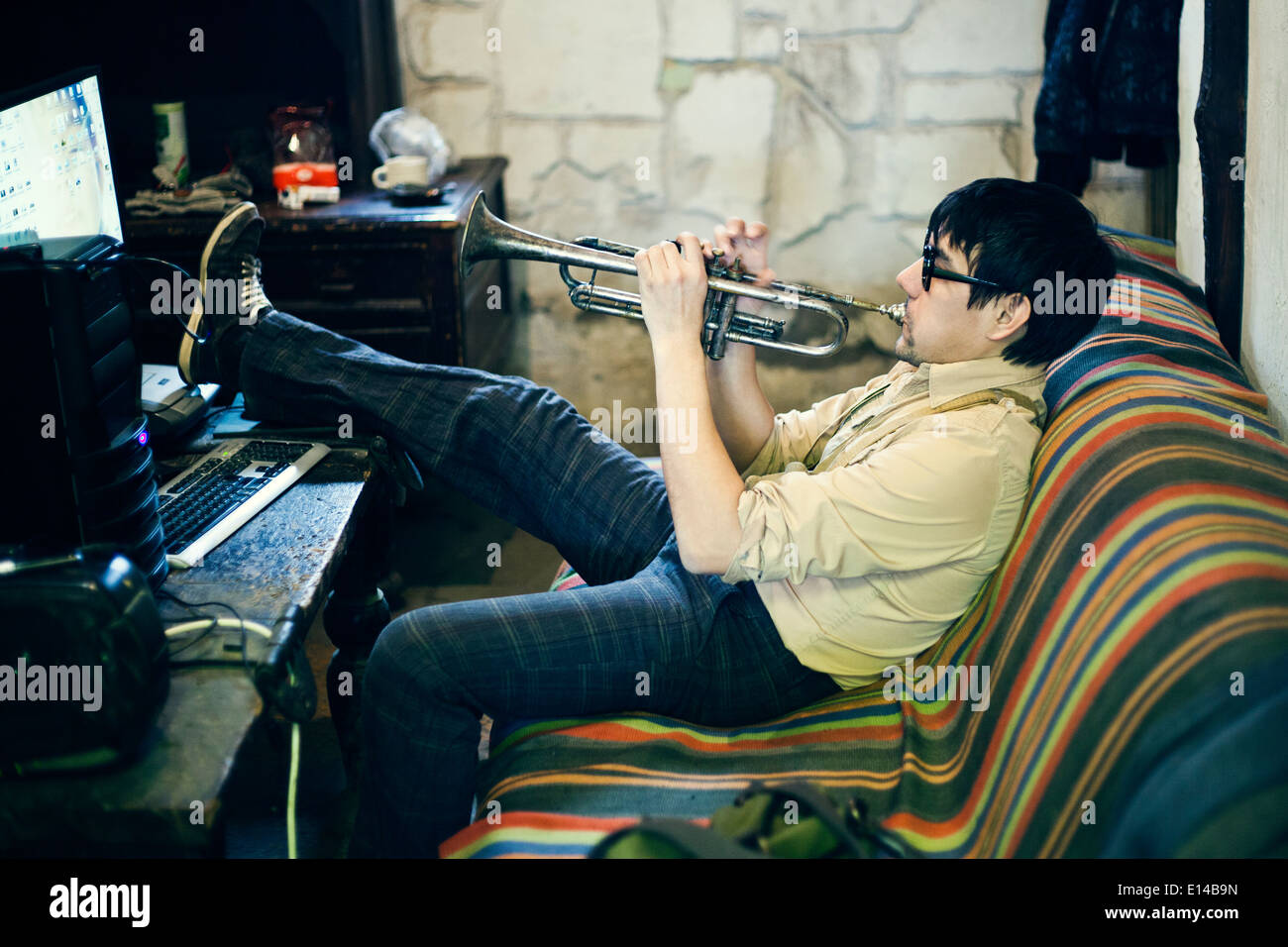 Mari man playing trumpet on sofa Stock Photo - Alamy