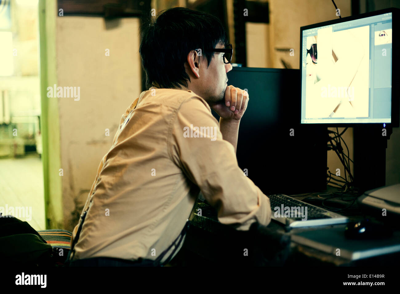 Mari man using computer at desk Stock Photo - Alamy