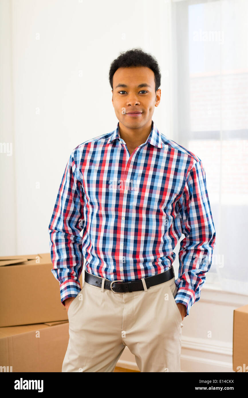 Mixed race man standing in new home Stock Photo - Alamy
