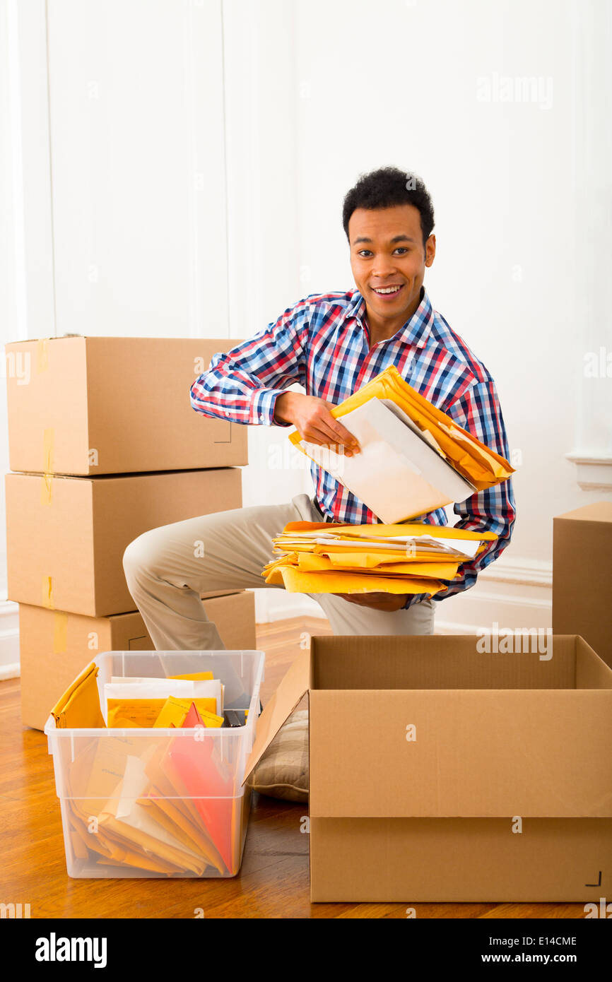 Mixed race man packing cardboard boxes Stock Photo - Alamy
