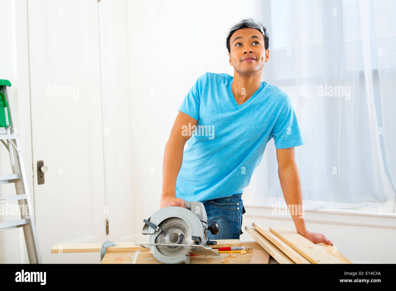 Mixed race carpenter thinking Stock Photo - Alamy