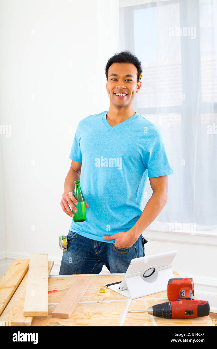 Mixed race carpenter drinking sparkling water Stock Photo - Alamy