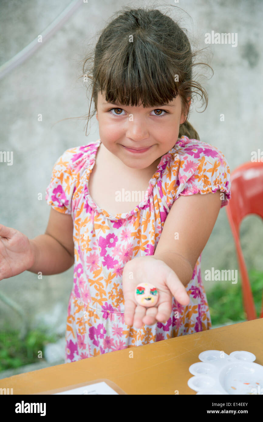 Caucasian girl holding painted rock Stock Photo - Alamy