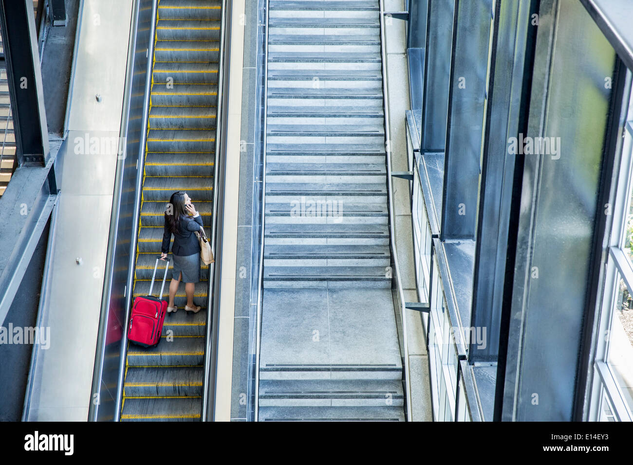 Businesswomen riding escalator Stock Photo - Alamy