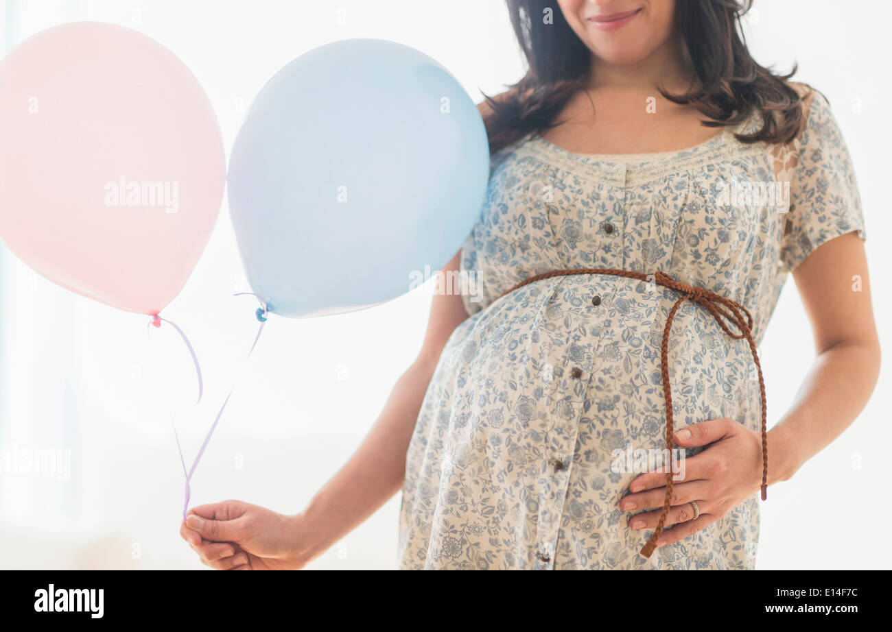 Pregnant Hispanic woman carrying balloon Stock Photo - Alamy
