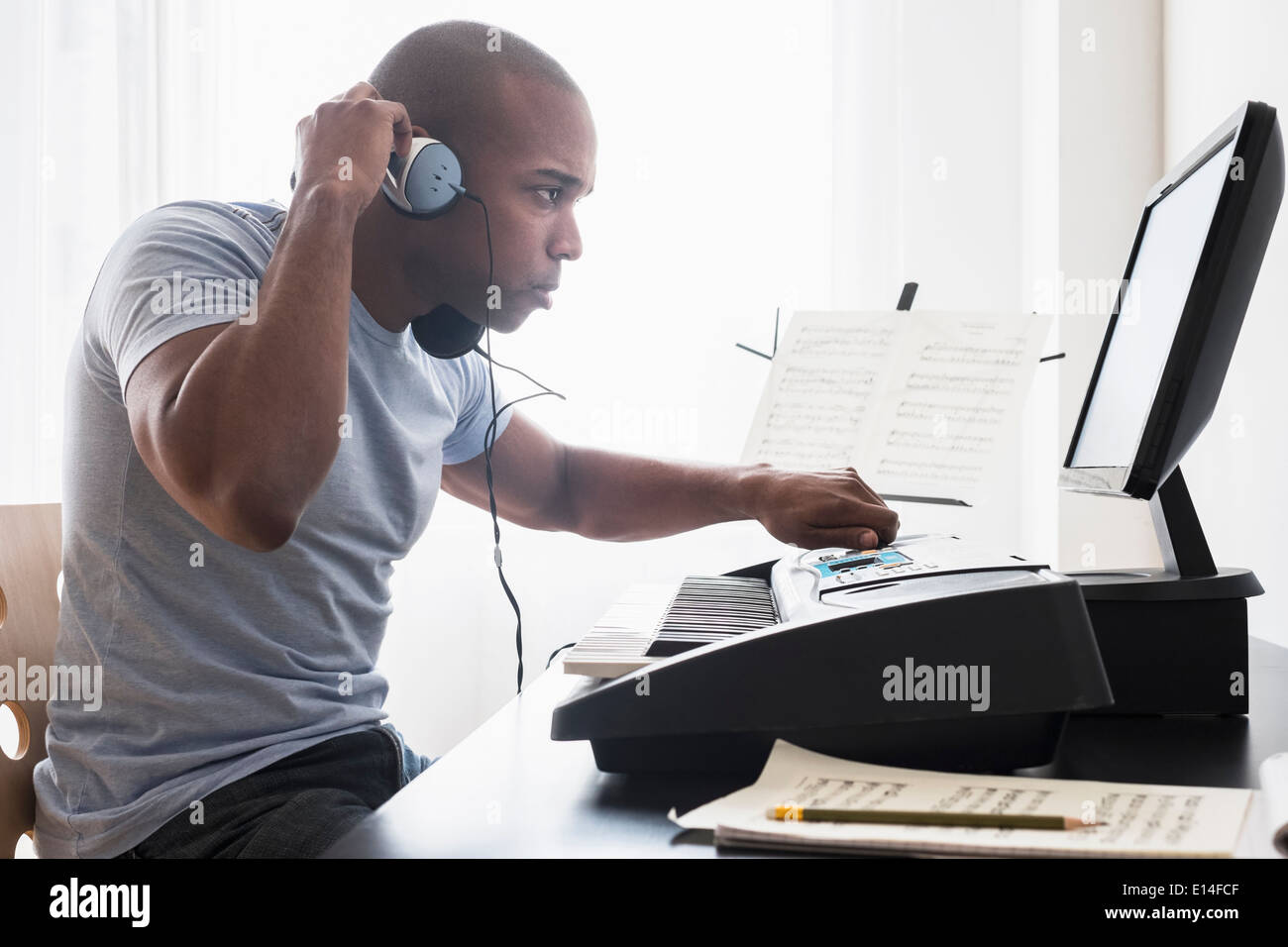 Black musician writing music with computer Stock Photo - Alamy
