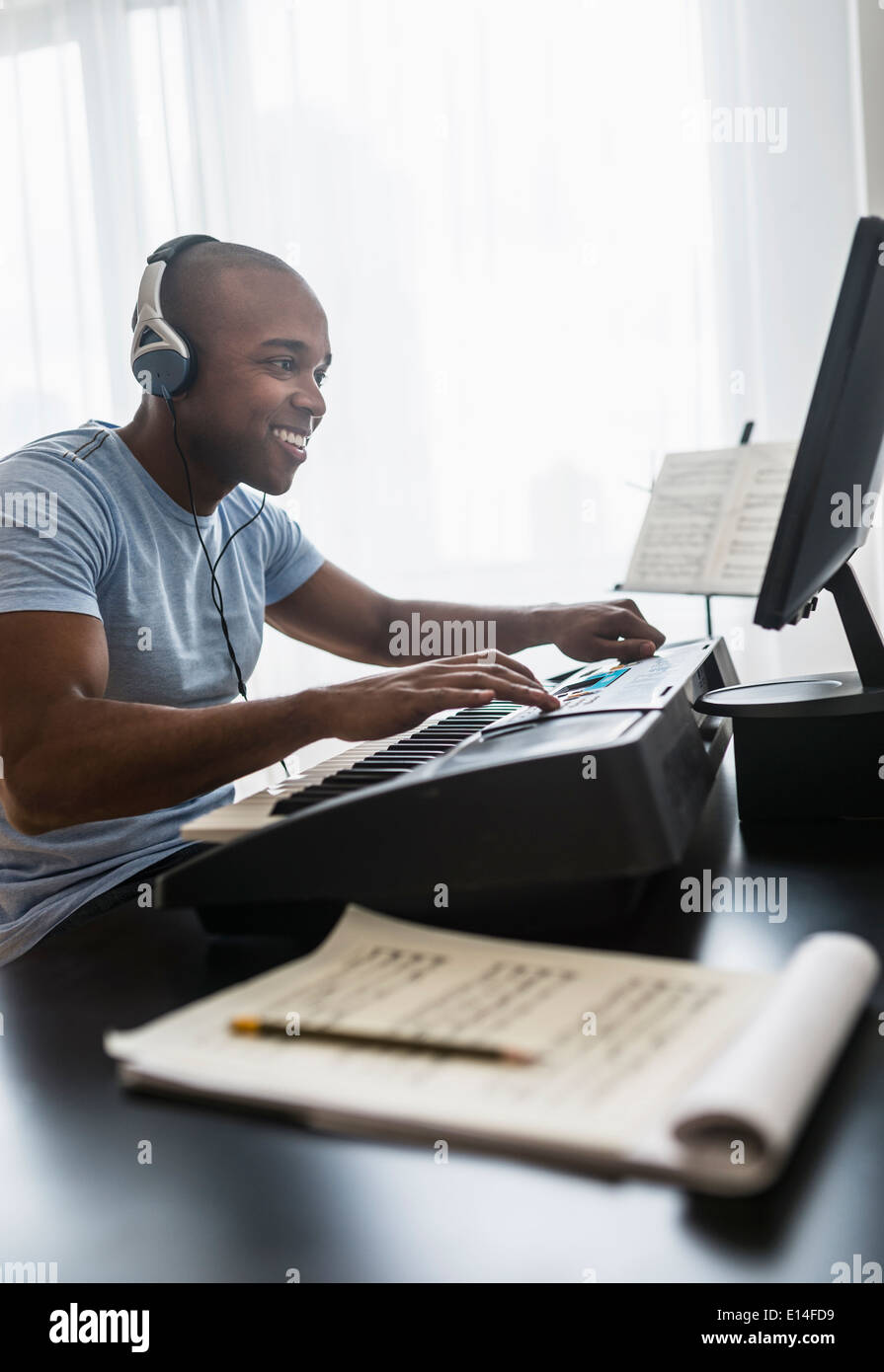 Black musician writing music on computer Stock Photo - Alamy
