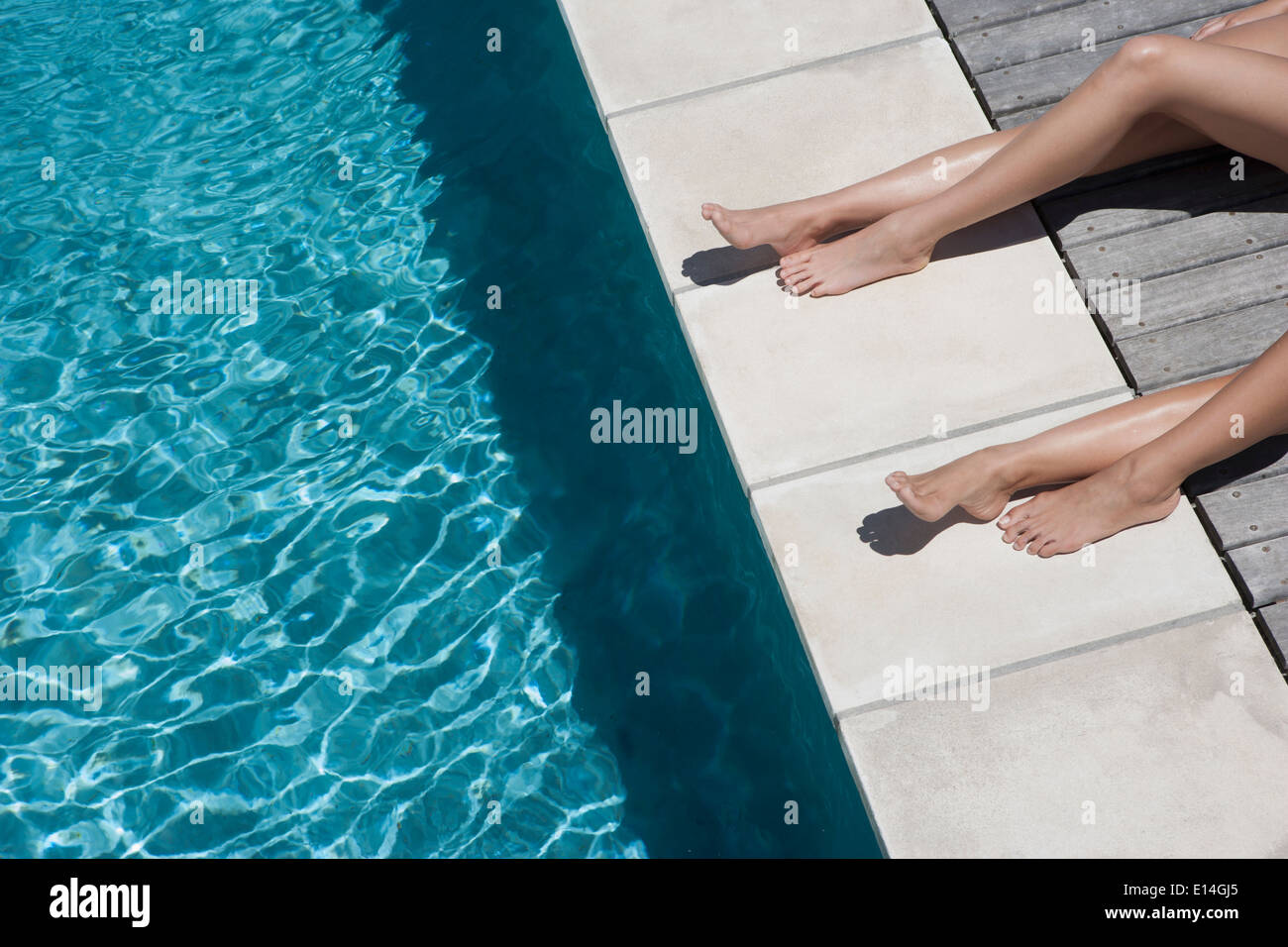 Caucasian women sunbathing by swimming pool Stock Photo - Alamy