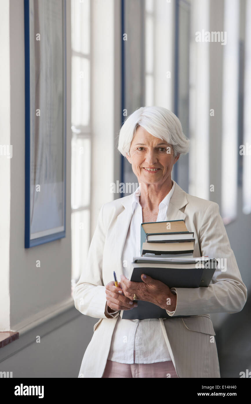 Businesswoman carrying books hi-res stock photography and images - Alamy