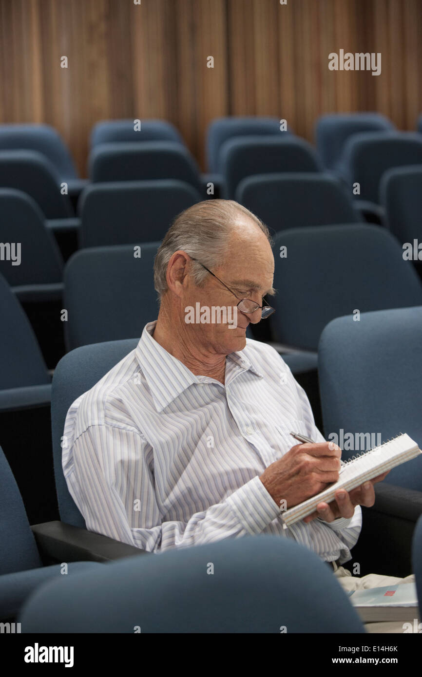 Senior Caucasian student taking notes in classroom Stock Photo - Alamy