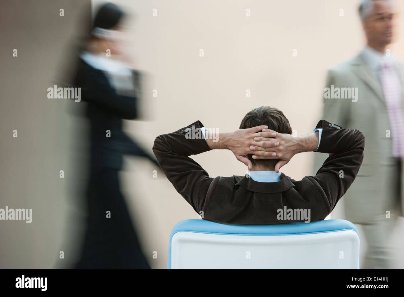 Businessman relaxing in busy lobby Stock Photo - Alamy