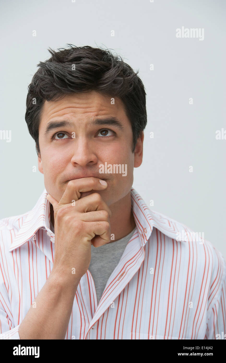 Man thinking with chin in hand Stock Photo - Alamy