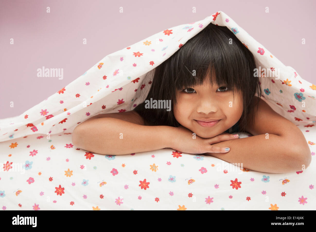 Chinese girl laying under covers Stock Photo - Alamy