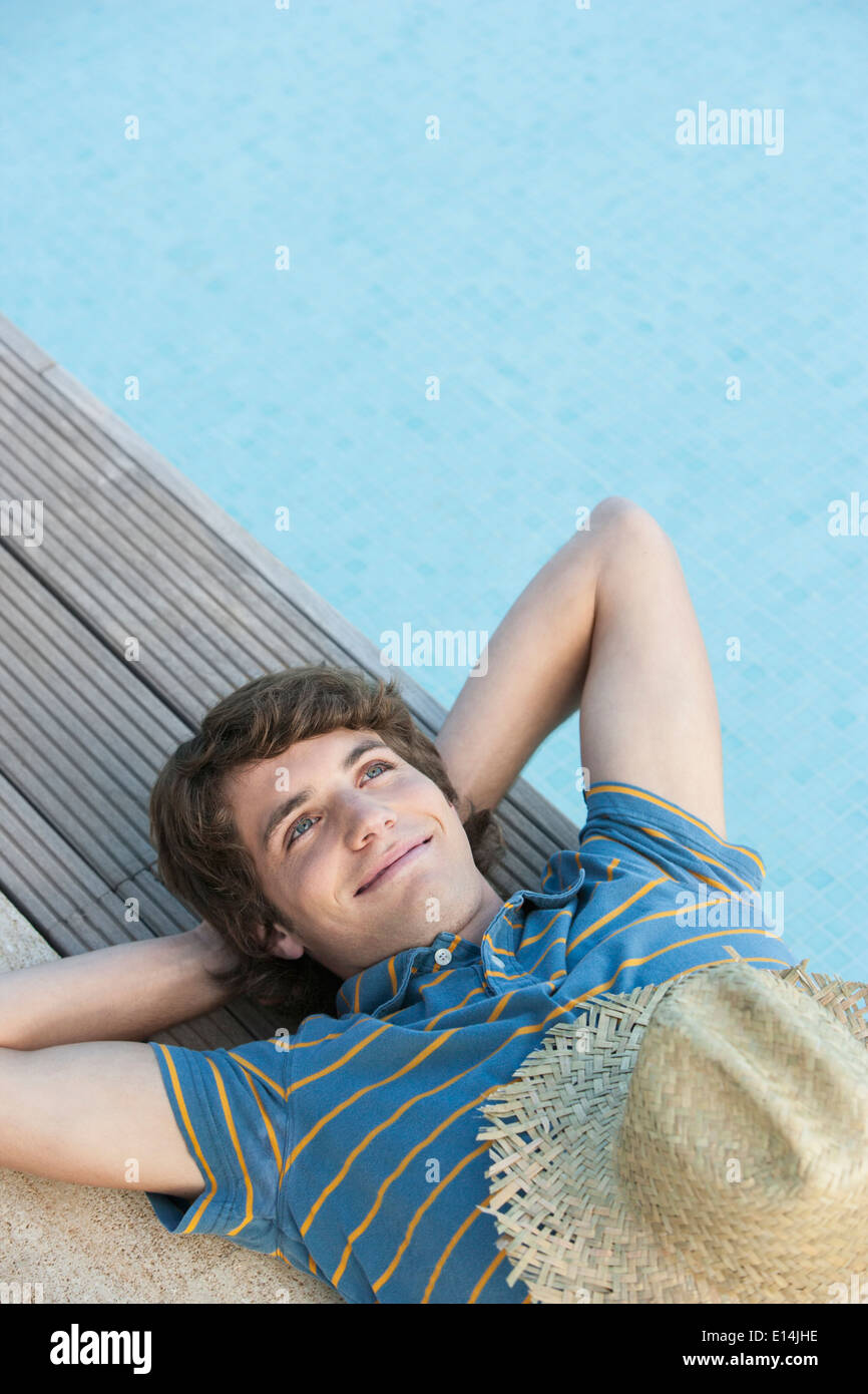 Man relaxing by swimming pool Stock Photo - Alamy