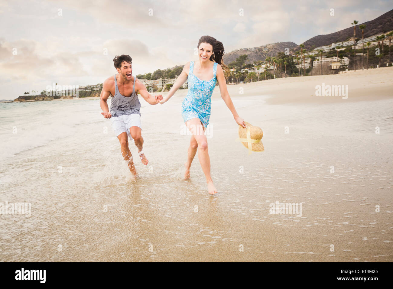 Caucasian couple running on beach hi-res stock photography and images ...