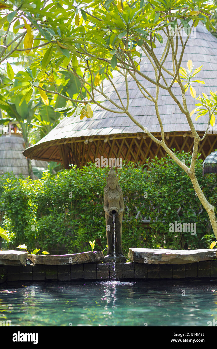 Statue fountain emptying into tropical pool Stock Photo - Alamy